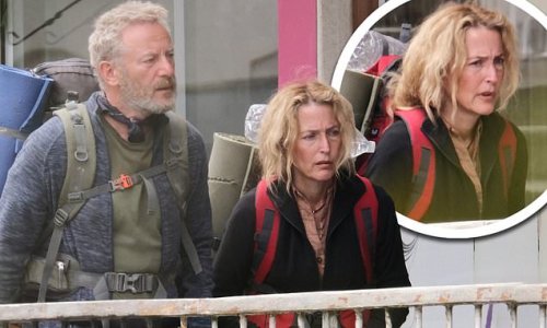 Gillian Anderson and Jason Isaacs look exhausted as they share a passionate kiss while filming ...
