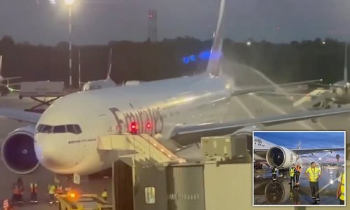 Emirates flight is grounded with smoke pouring from its rear moments ...