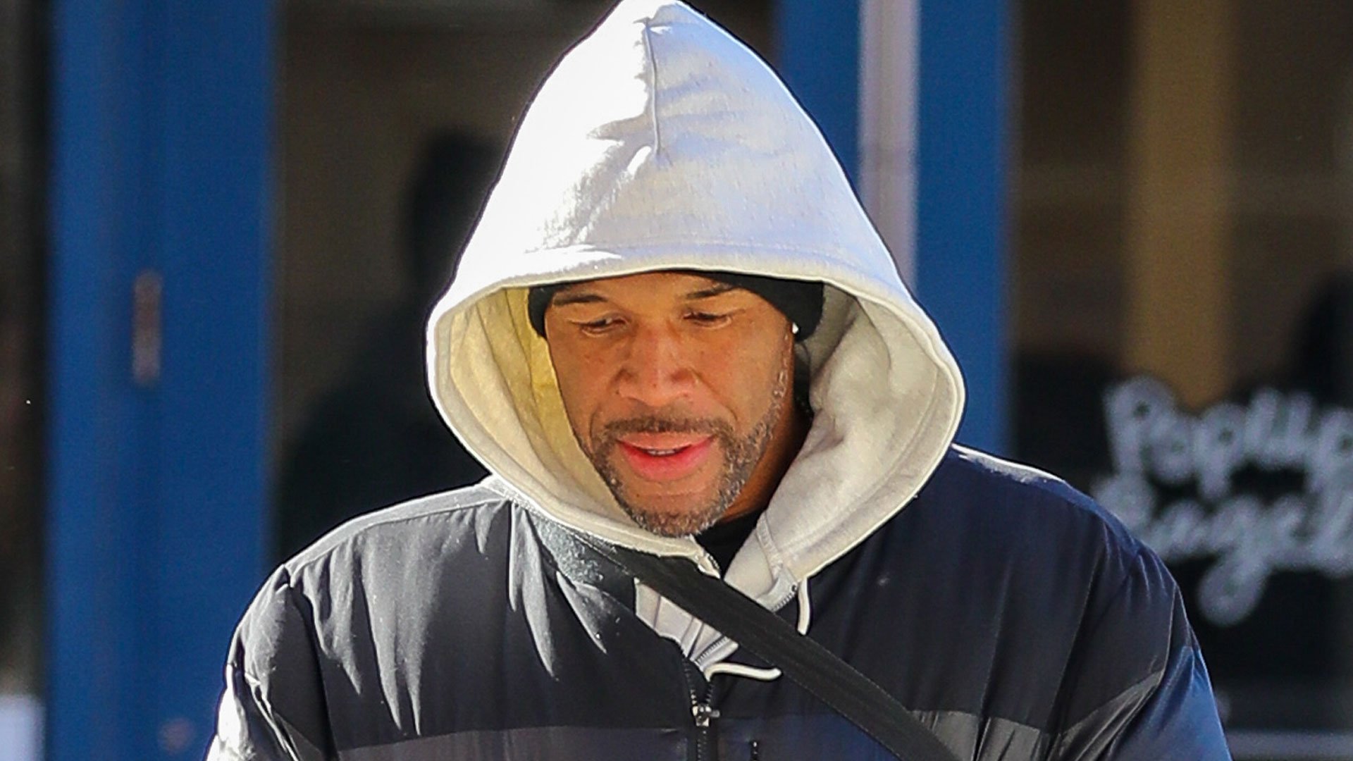 TOUGH STRA Downbeat Michael Strahan keeps a low profile with hood up ...